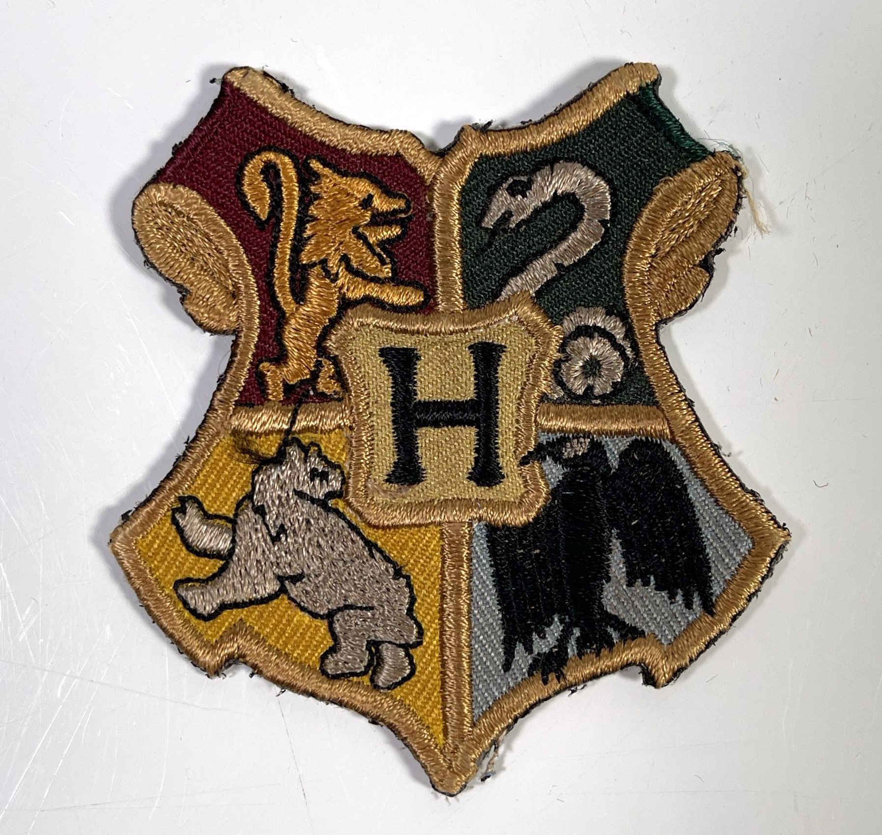 Lot 225 - HARRY POTTER EMBROIDERED HOGWARTS BADGE.