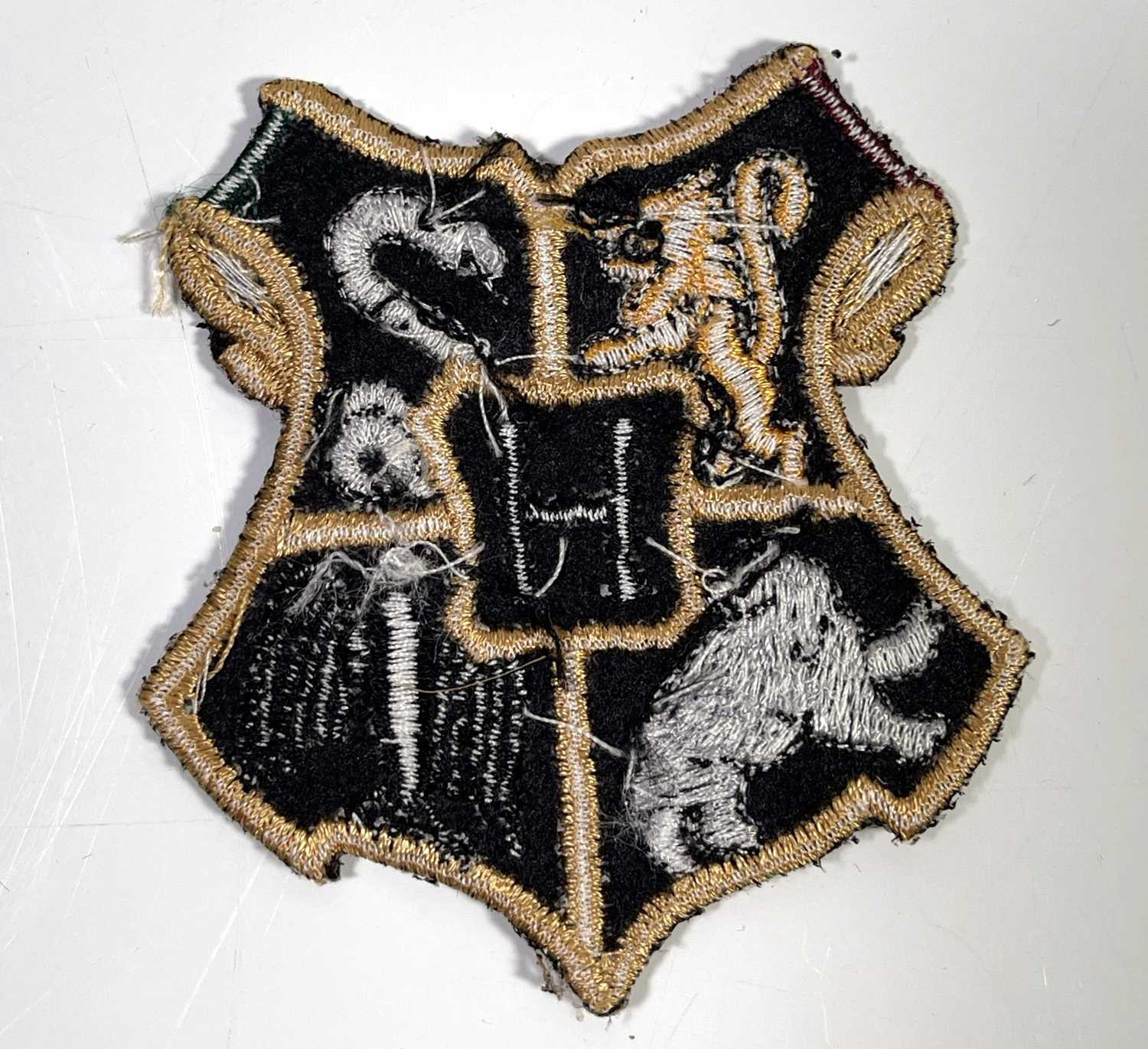 Lot 225 - HARRY POTTER EMBROIDERED HOGWARTS BADGE.