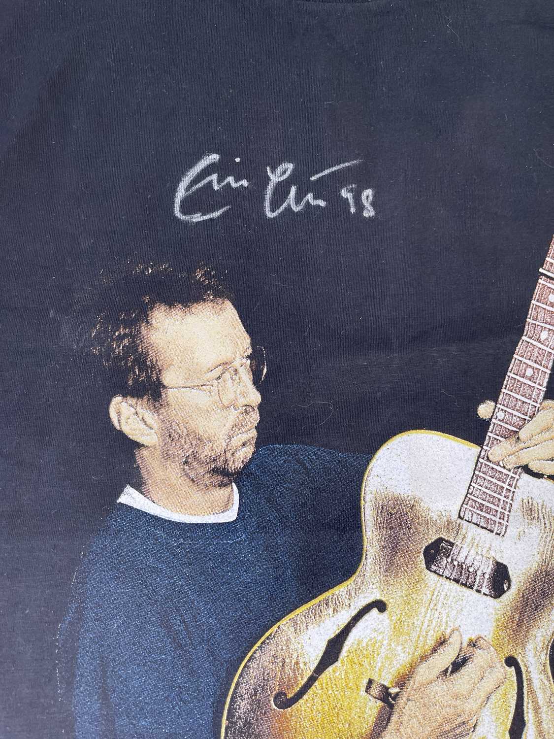 Lot 411 - ERIC CLAPTON - SIGNED T-SHIRT AND PHOTO.